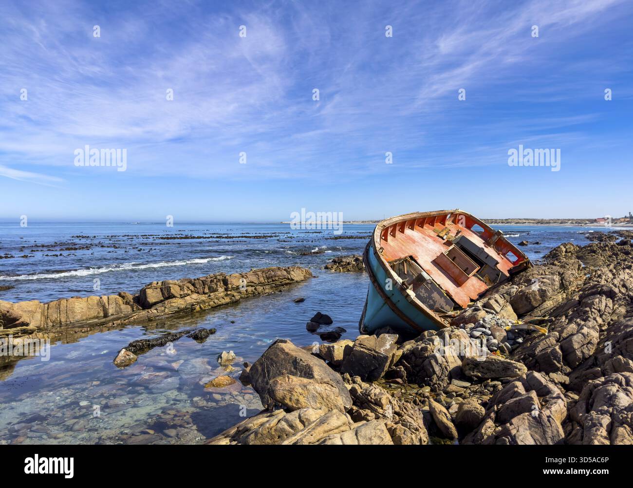 Shipwrecked diamond mining vessel on rocky shoreline in small West ...