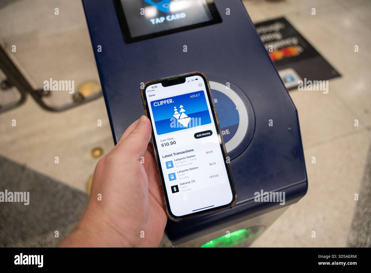 Hand holding smartphone displaying Clipper card in mobile wallet above ...