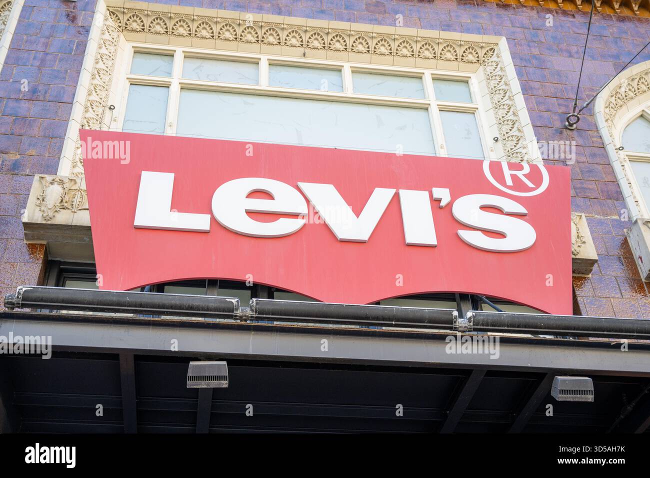 Red Levi's logo sign on storefront facade of historic tiled building ...