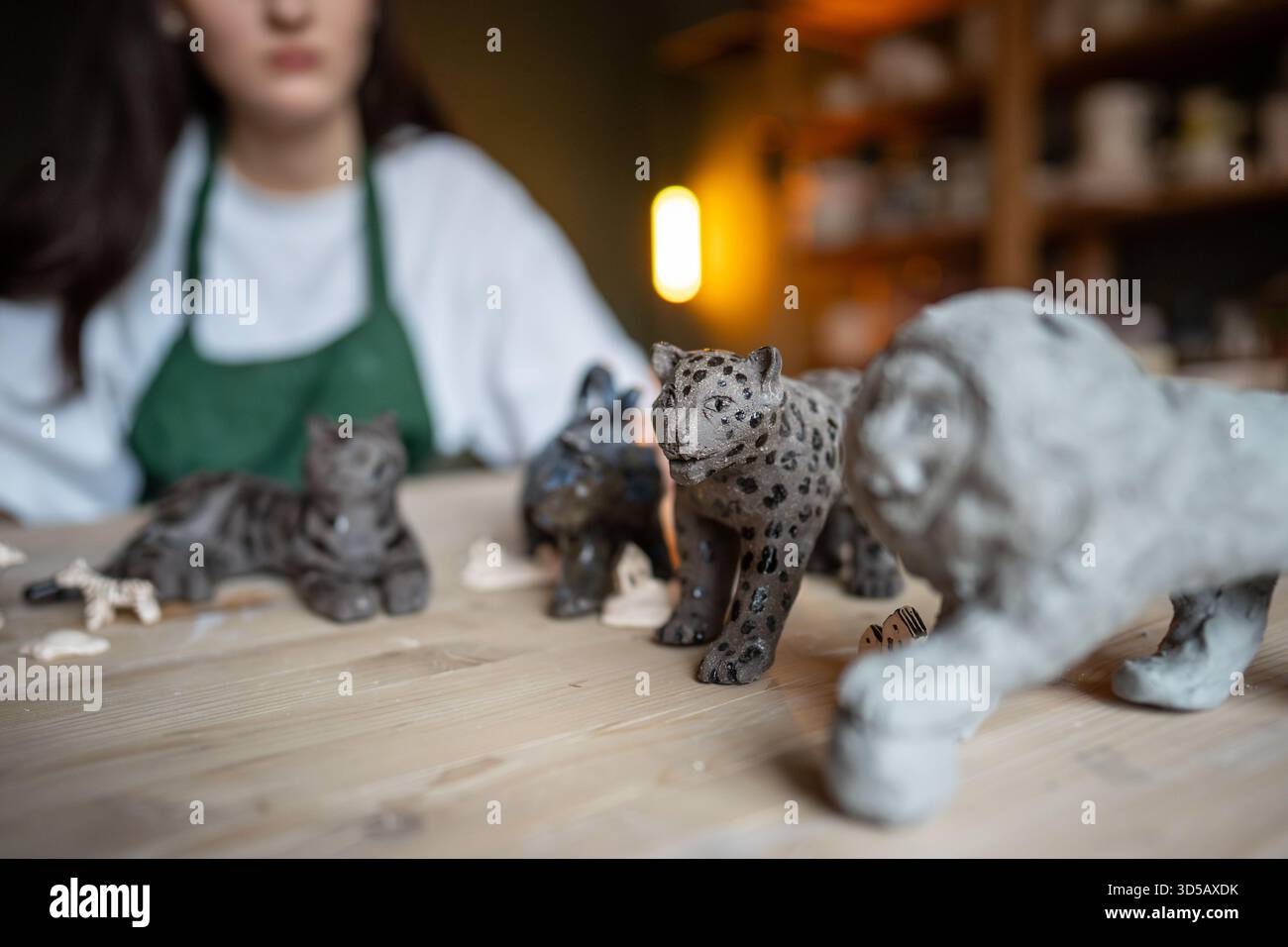 Ceramic figures of wild cats in pottery workshop. Clay craftsmanship ...