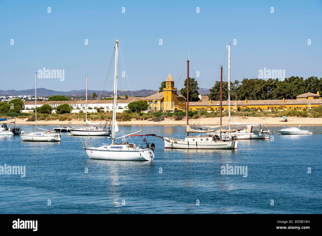 Sailboats anchored in the Gilão River, off Praia da Ilha de Tavira ...