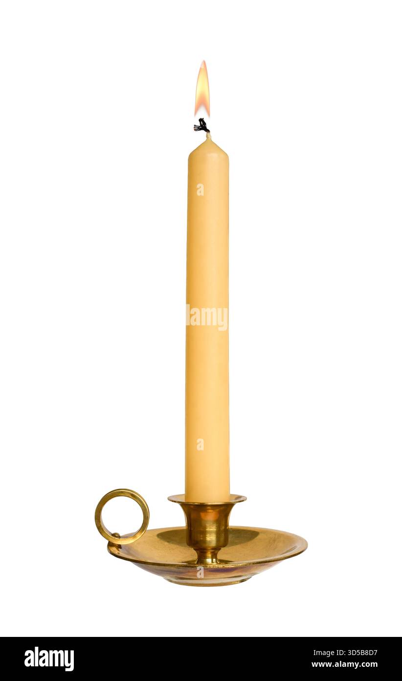 Old-fashioned brass candle holder with a side handle and a lit taper ...