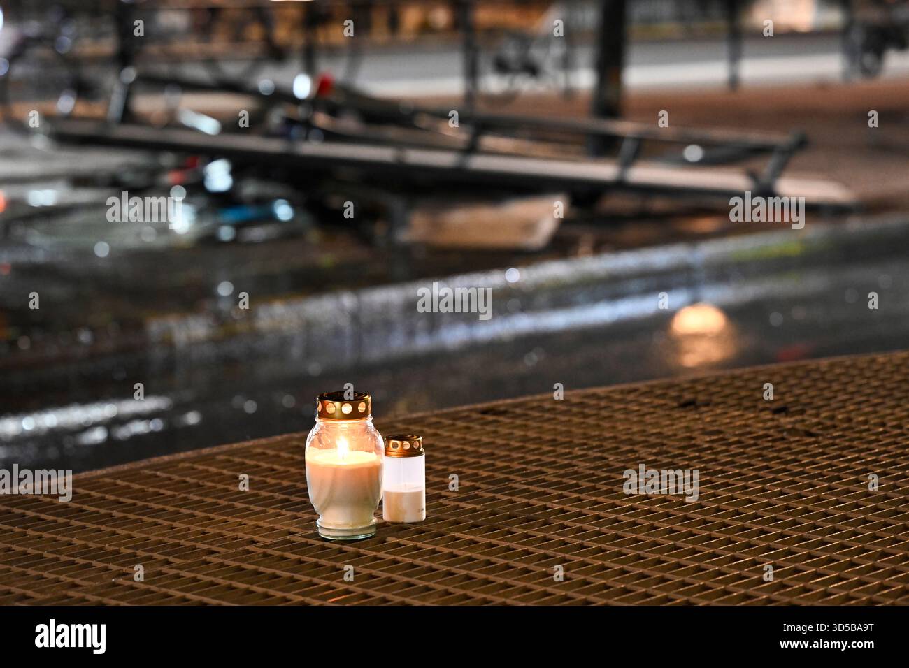 Lighted candles for the three victims at the scene of the accident ...