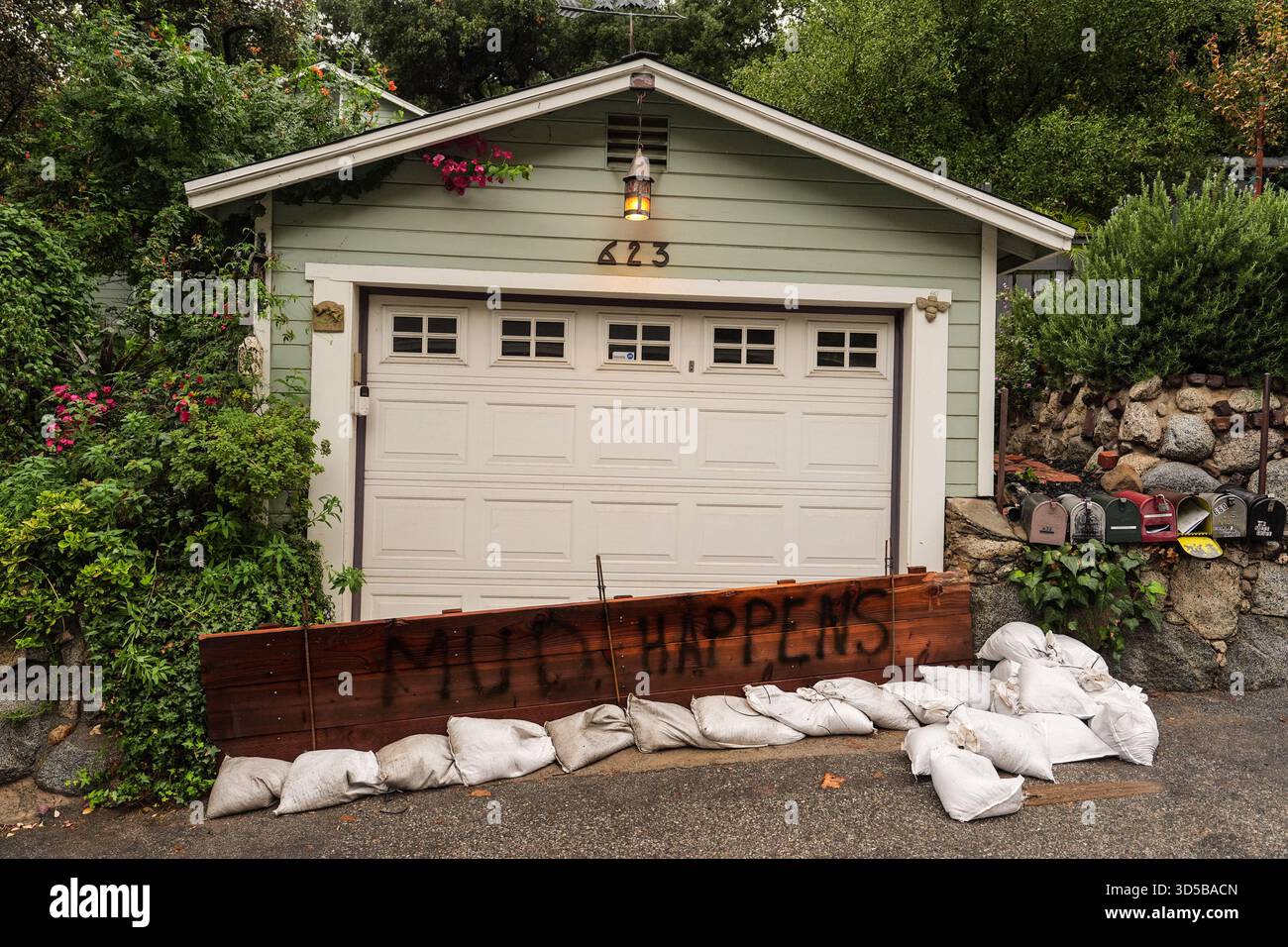 A mud fence and sandbags sit in front of a garage in Sierra Madre ...