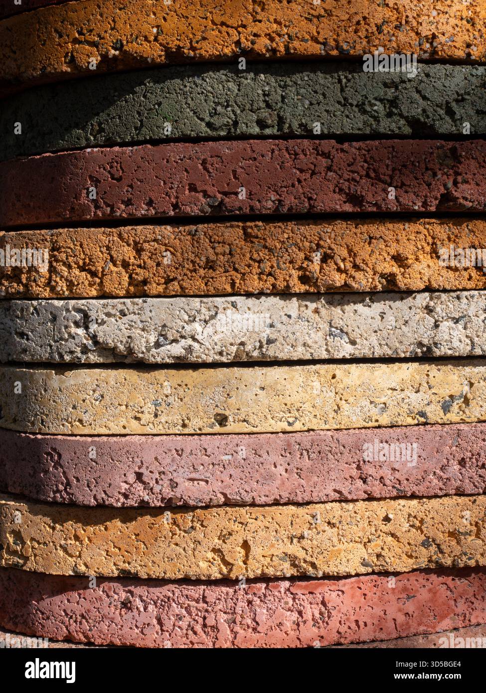 Close-up of stacked concrete paver rings in warm earthy colors and one ...