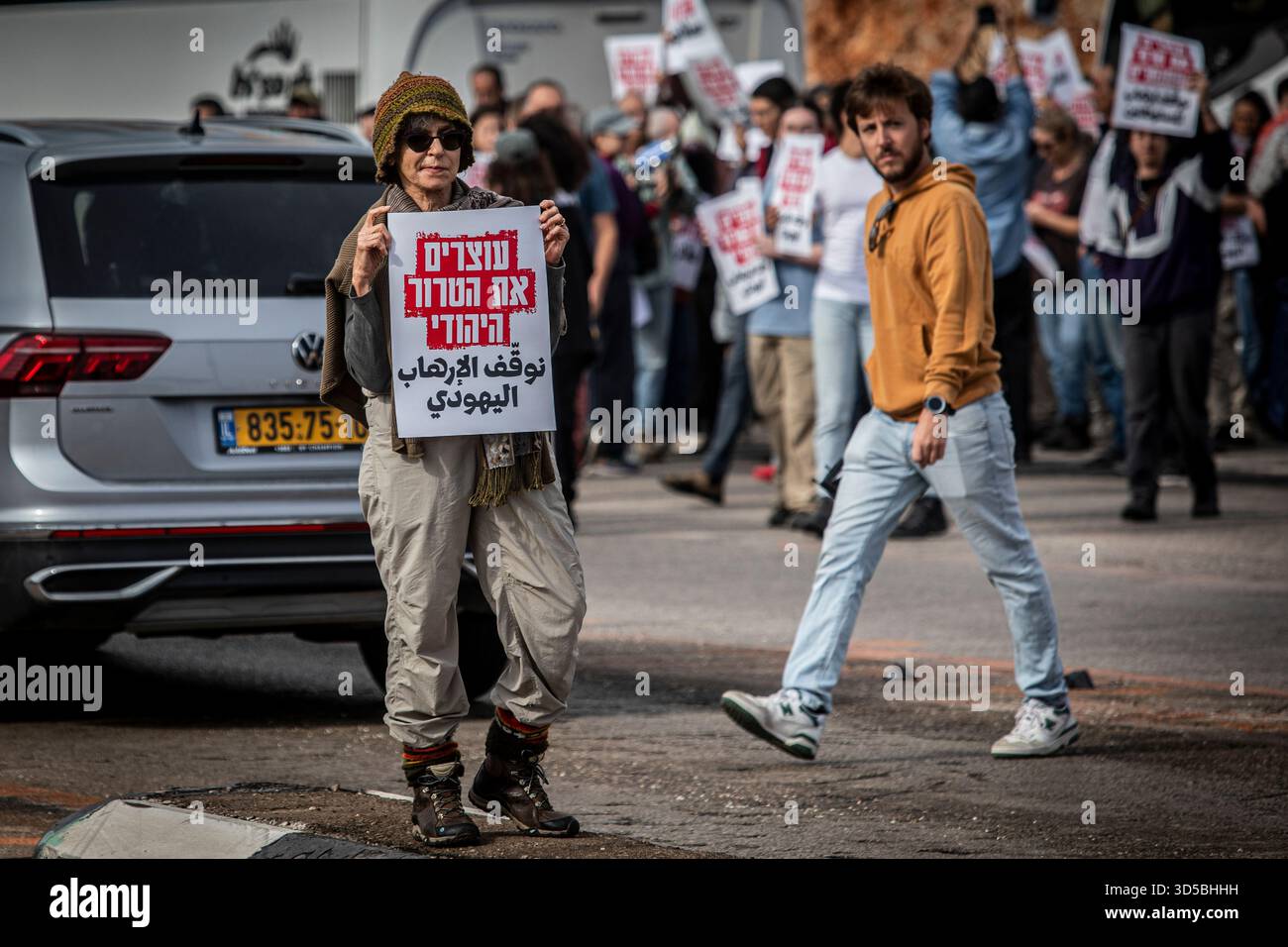 Oranit, Israel. 14th Nov, 2025. An Israeli peace activist holds up a ...