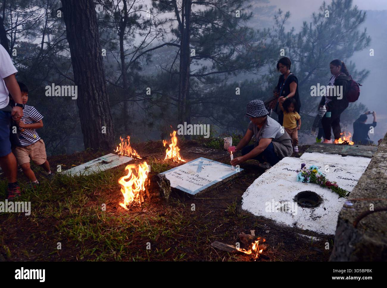 Families light bonfires at the grave of their ancestors at the night of ...