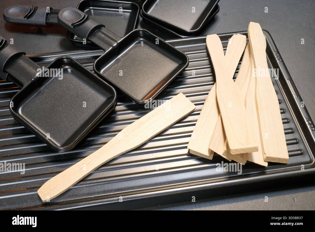 Raclette trays and wooden pallets on table from above Stock Photo - Alamy
