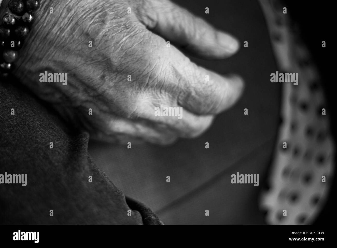 Elderly hand resting on lap, black and white Stock Photo - Alamy