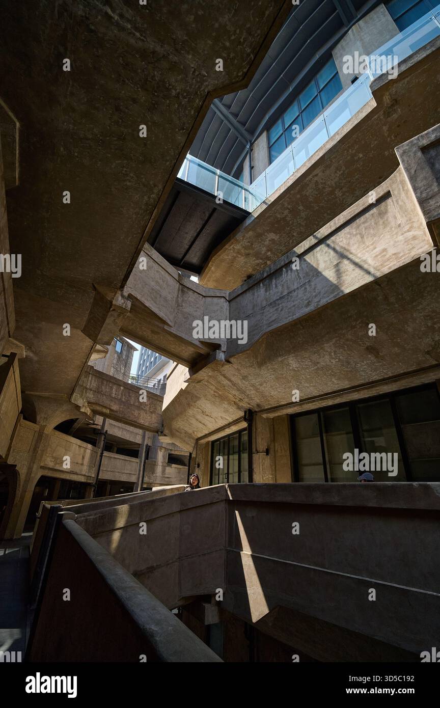 Brutalist concrete corridor with dual guardrails, receding perspective ...