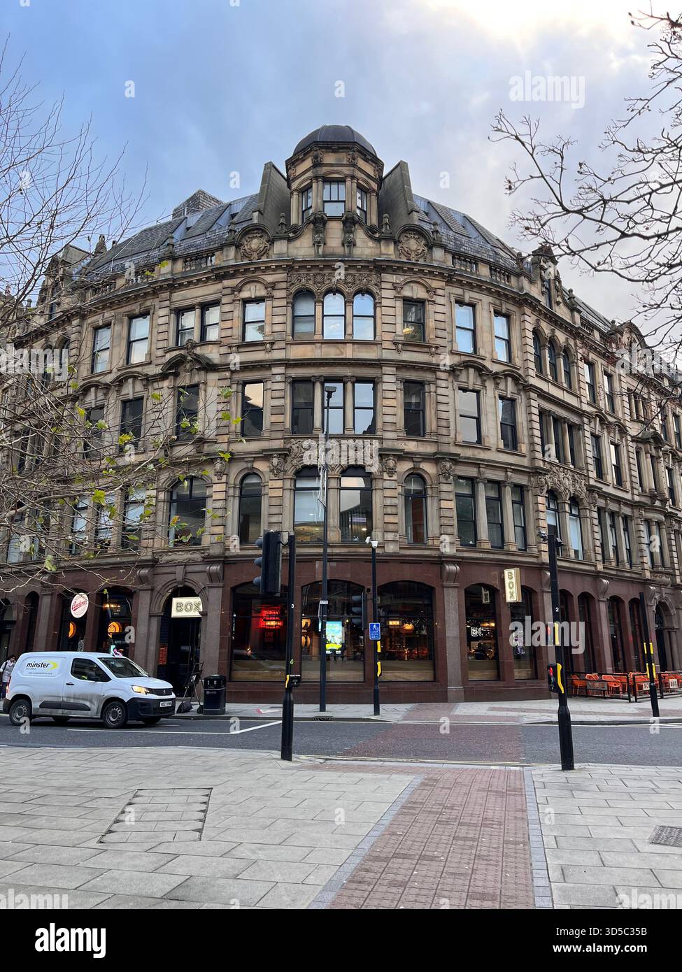 Grand historic stone corner building with large windows and shops at ...