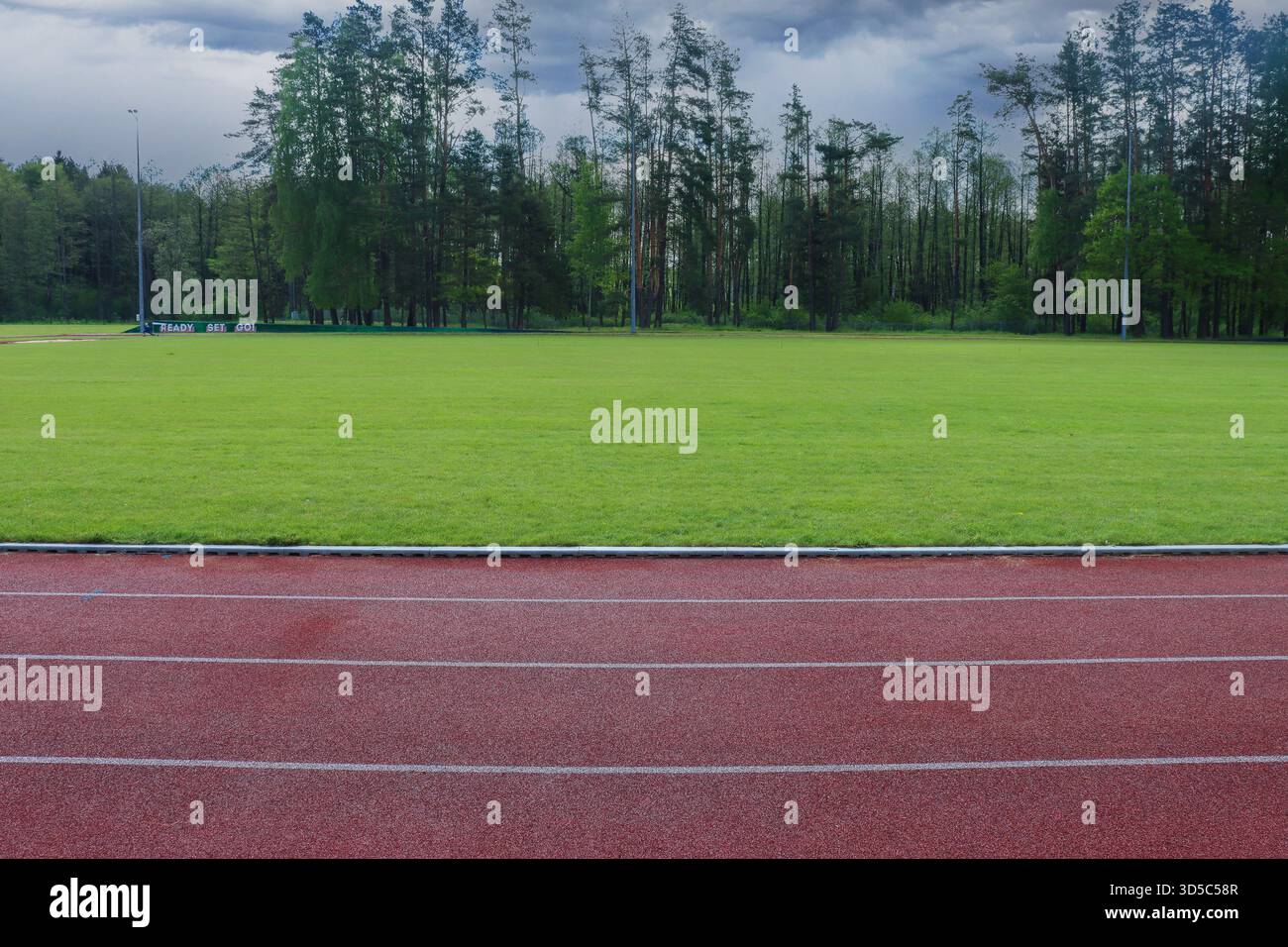 Red running track with white stripes markings at the stadium, green ...