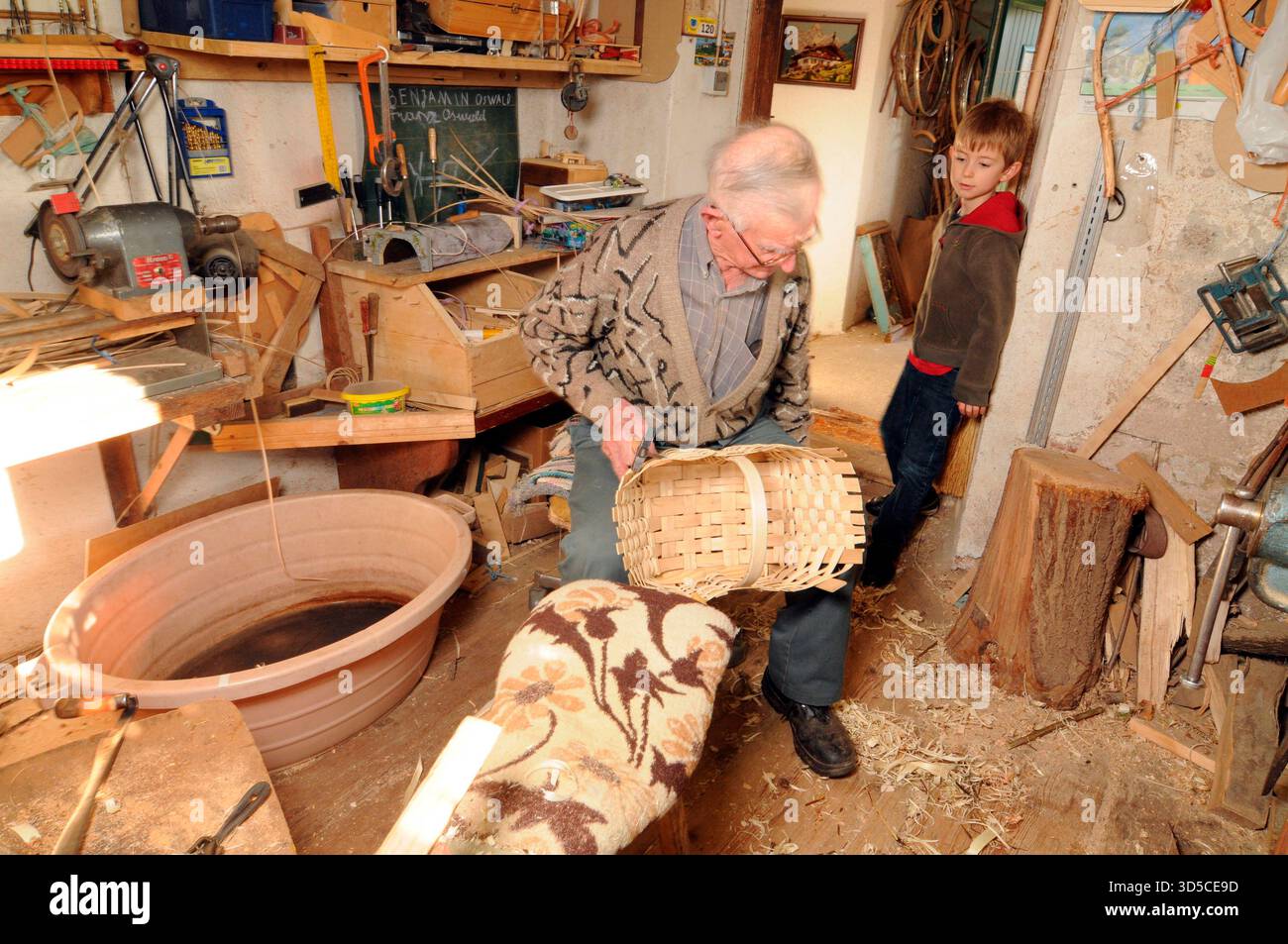 a basket maker weaves a basket, crafting and producing with wood a ...