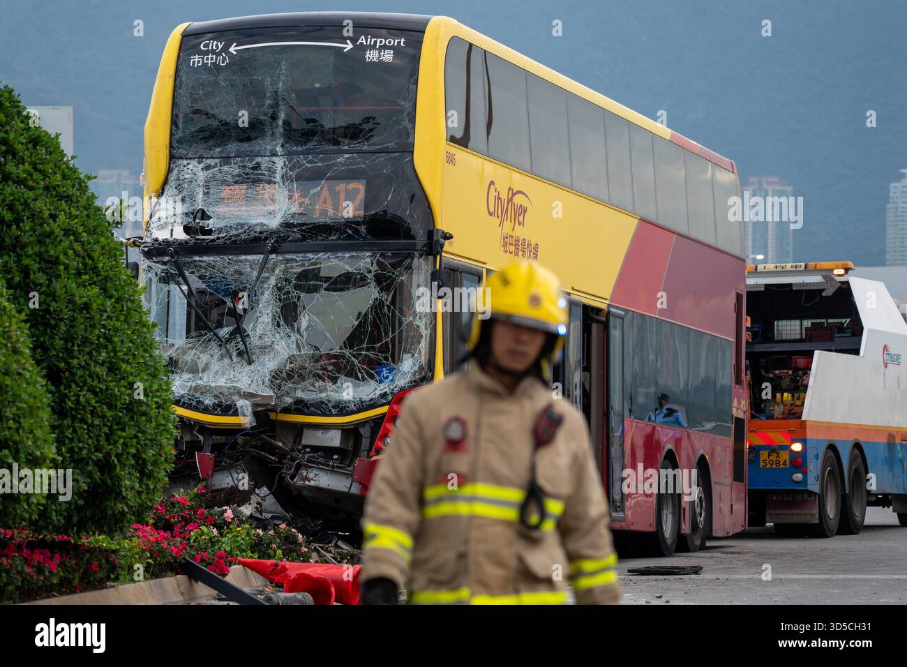A firefighter walks pass a double decker bus operated by Citybus ...