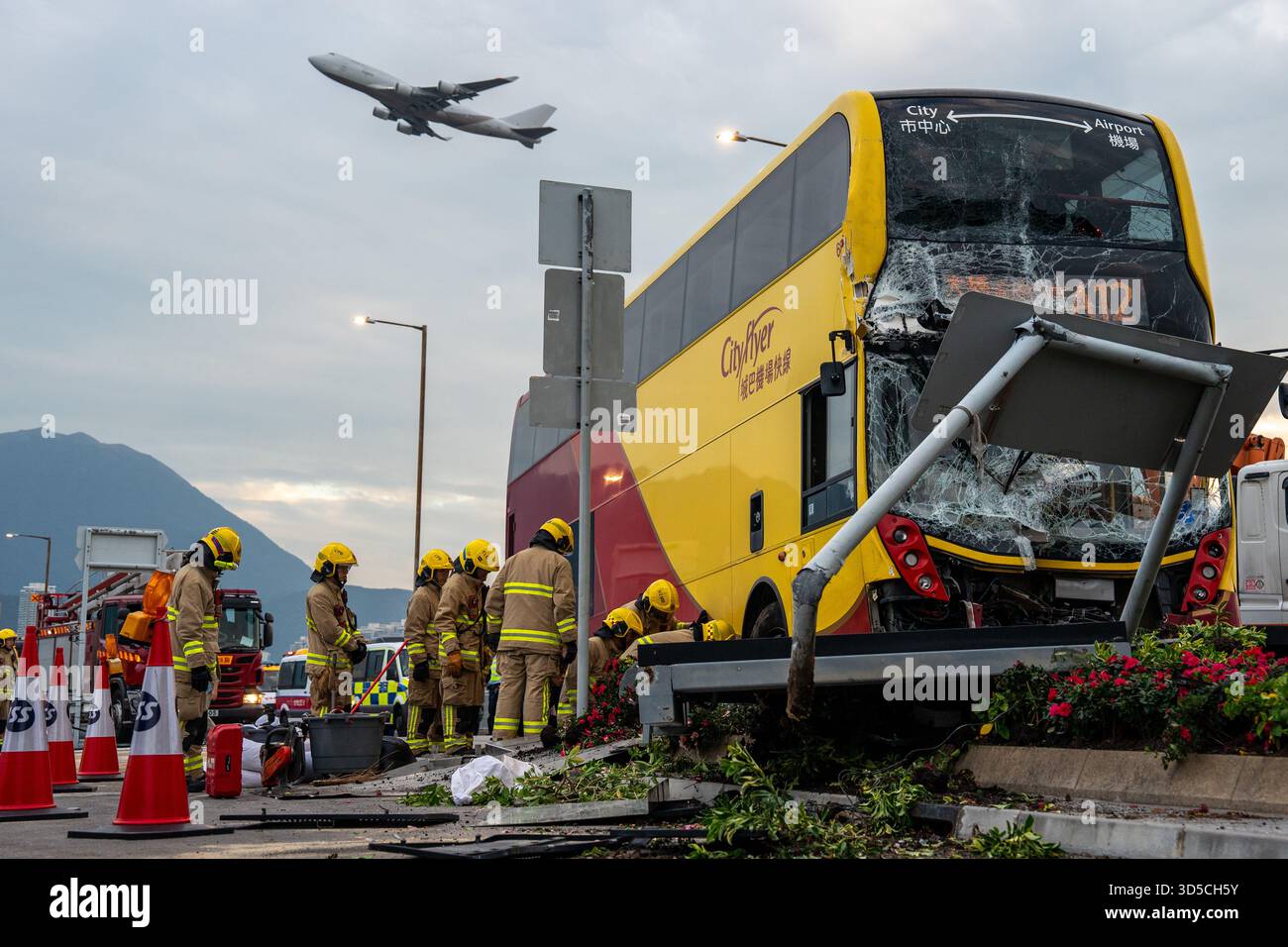 A plane taking off from the airport flying over a double decker bus ...