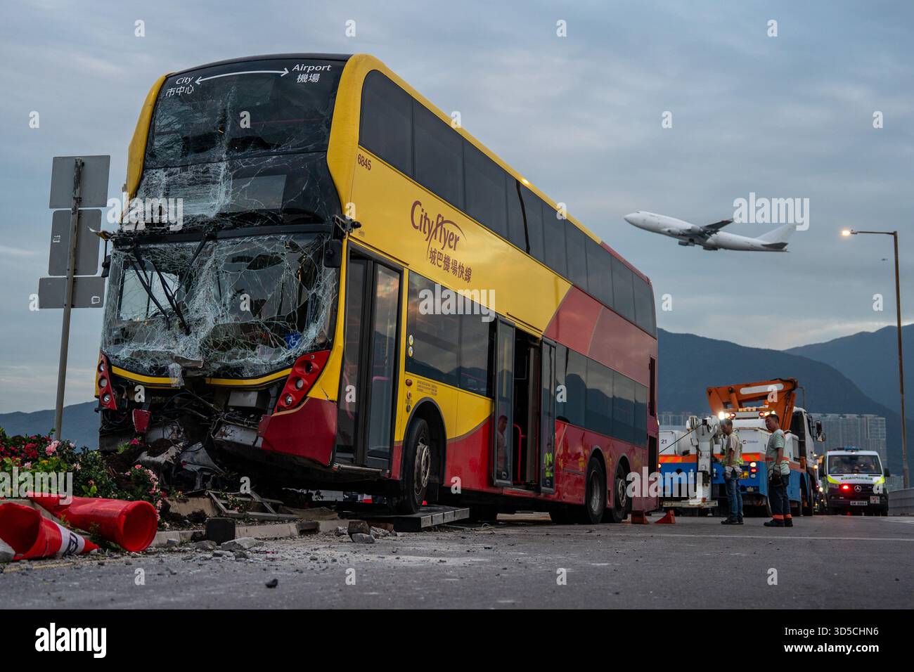 A plane taking off from the airport flying over a double decker bus ...