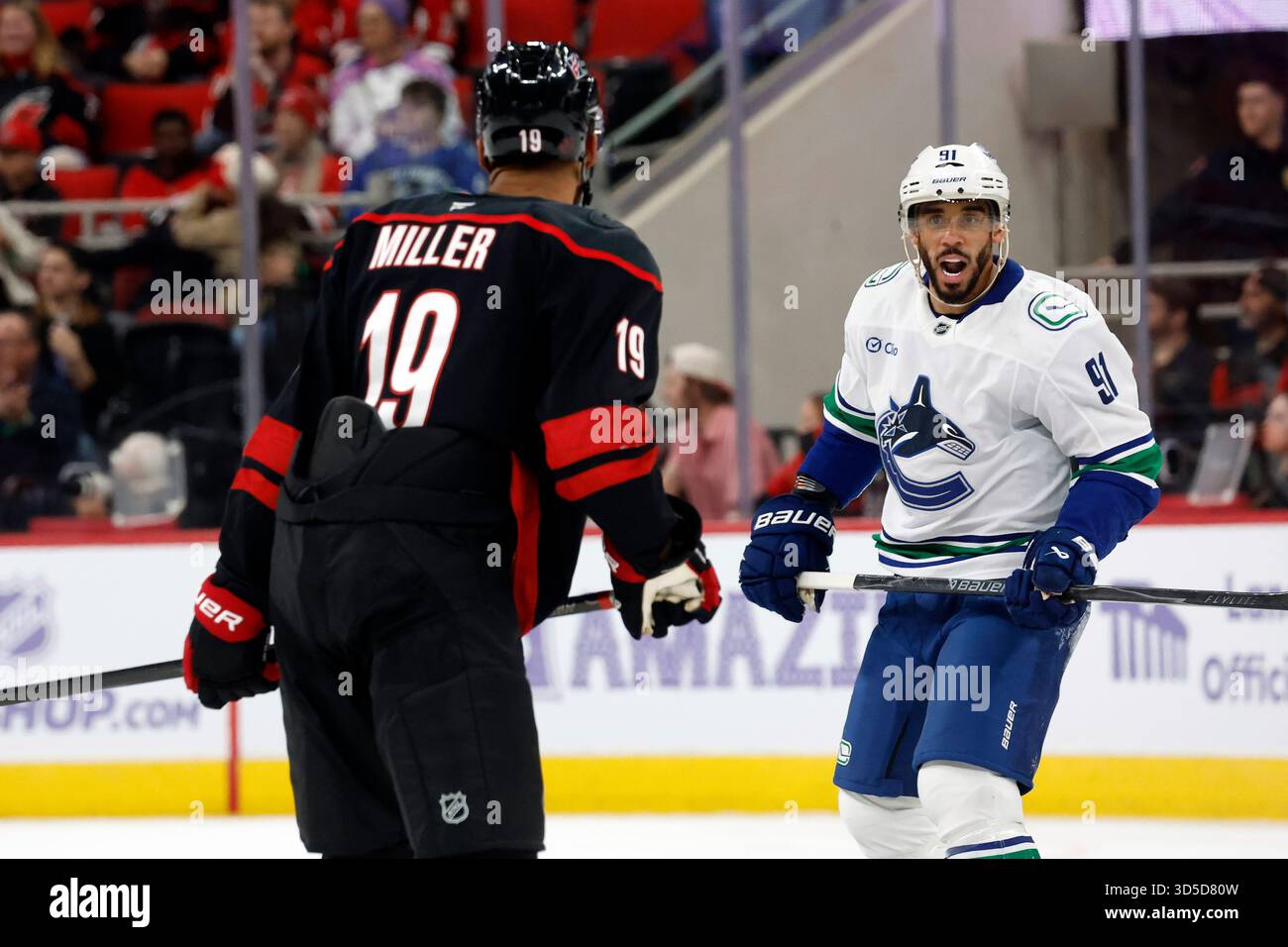 Carolina Hurricanes' K'Andre Miller (19) chirps at Vancouver Canucks' Evander Kane (91) during ...