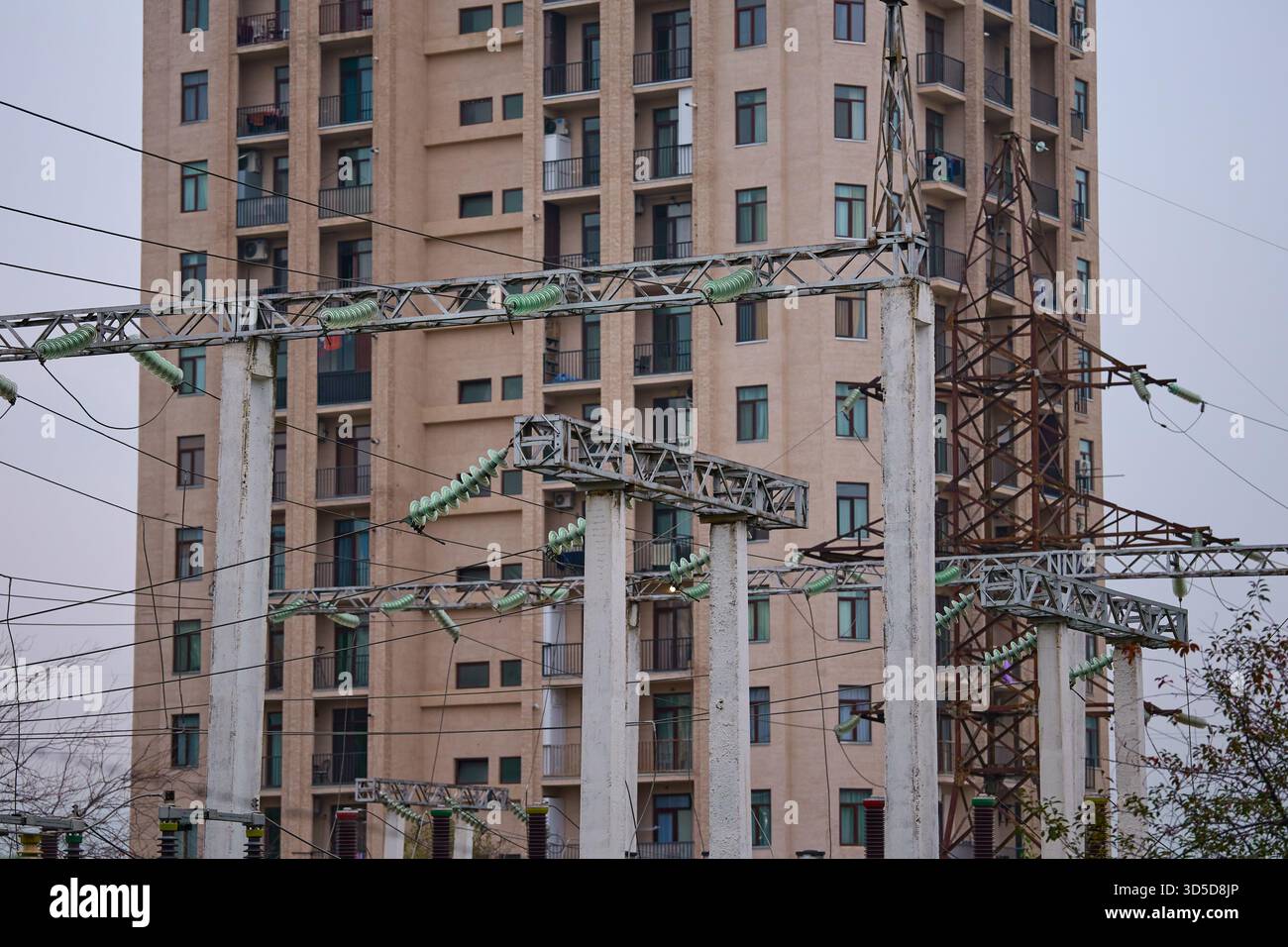 Power lines connect to a tall building in an urban area Stock Photo - Alamy