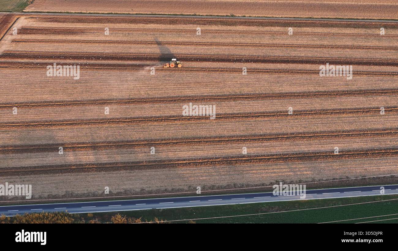 Tractor plowing expansive Po Valley field, carving straight furrows ...