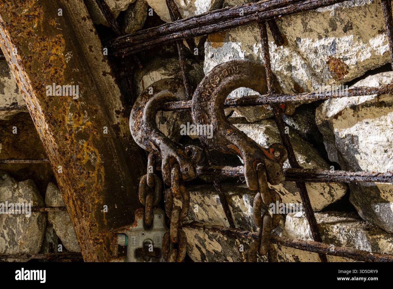 Heavy tools and equipment inside an underground mine, with steel chains ...