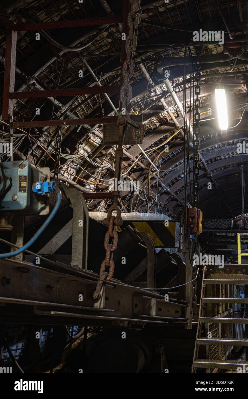 Heavy tools and equipment inside an underground mine, with steel chains ...