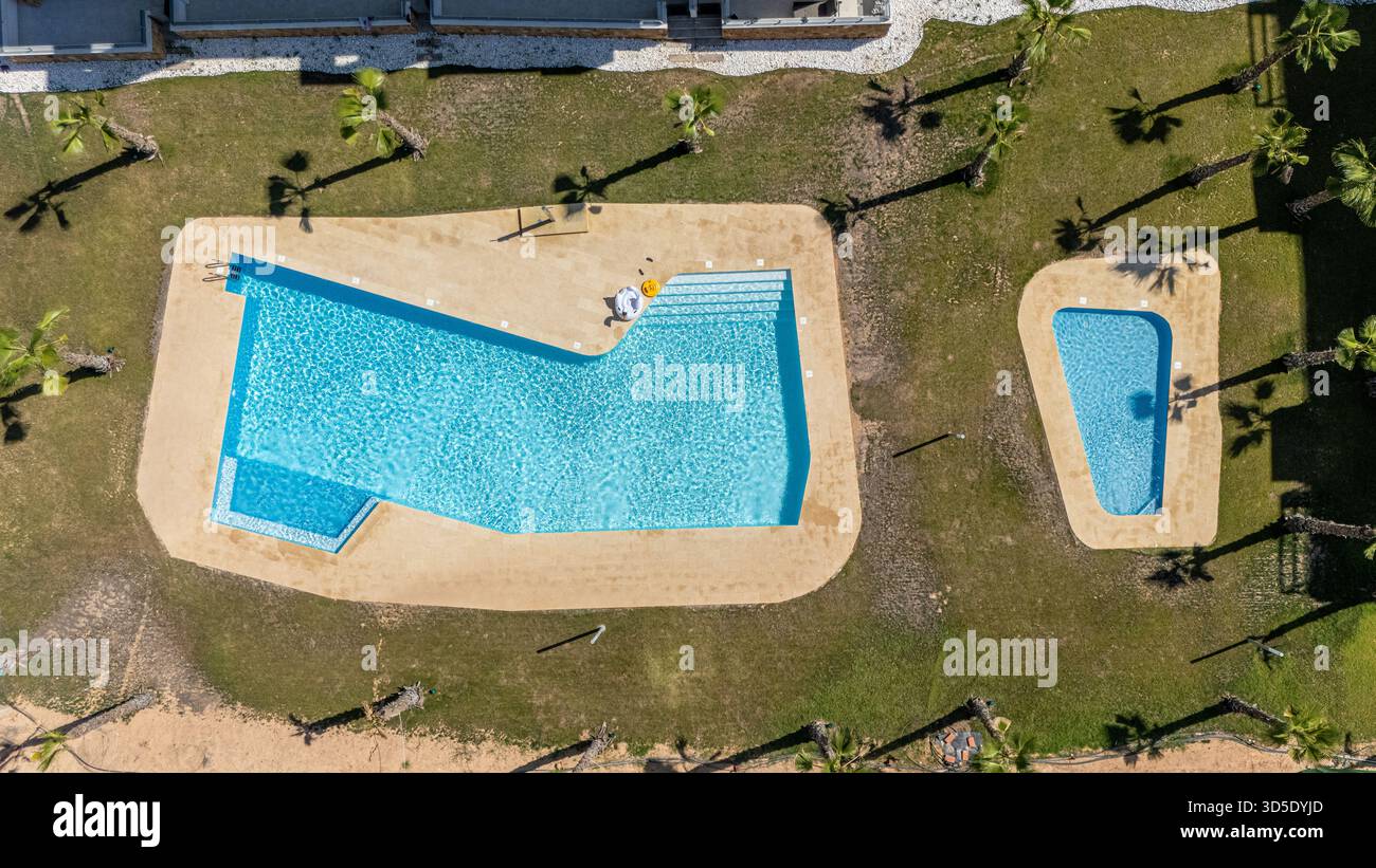 Drone view of large and small swimming pools with clear blue water, sun ...