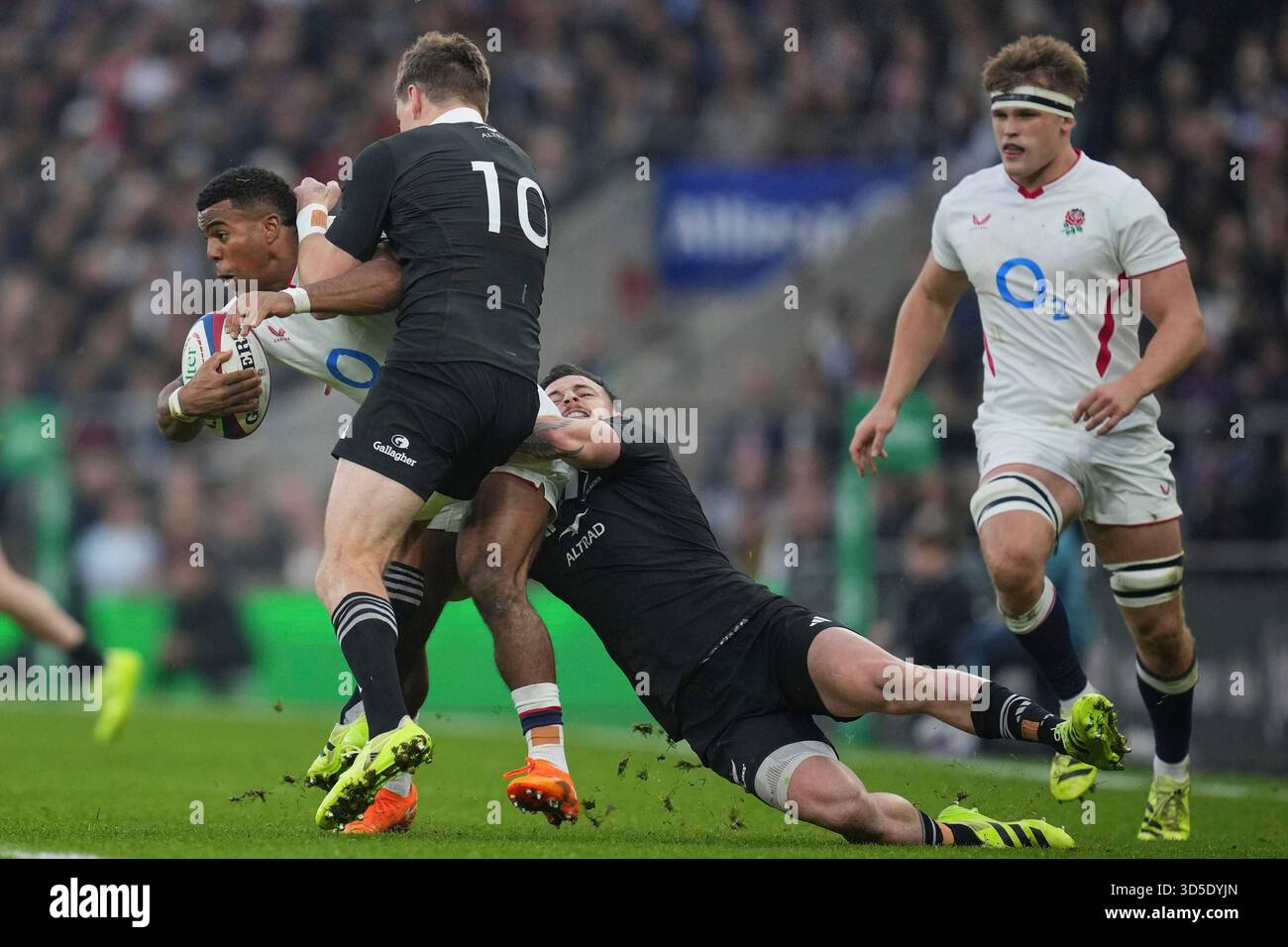 England Immanuel Feyi-Waboso, left, is tackled by New Zealand Beauden ...