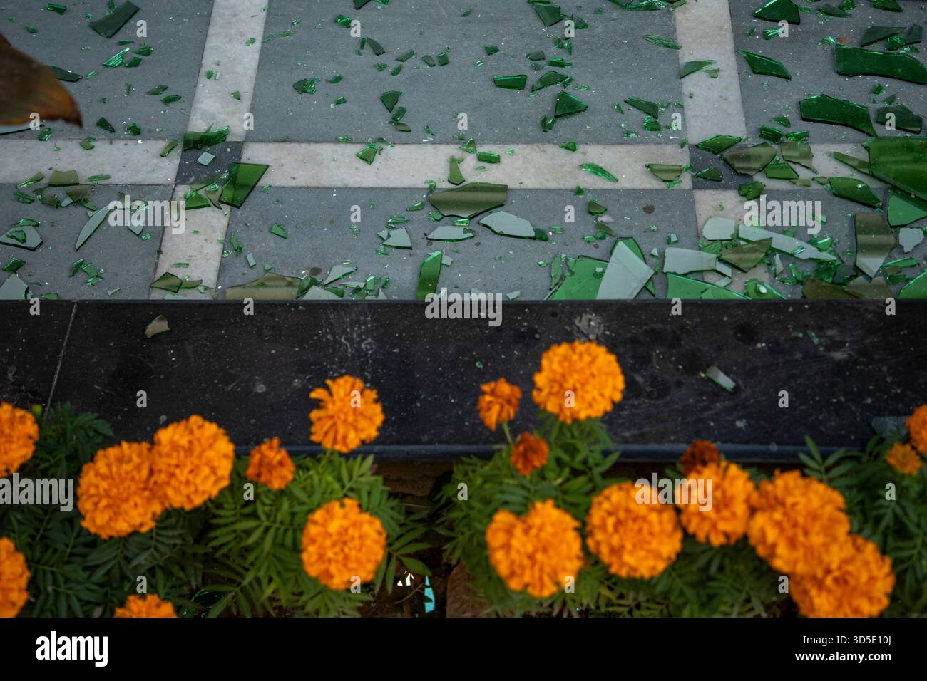 Shattered glass lies across the floor of a nearby house after the ...