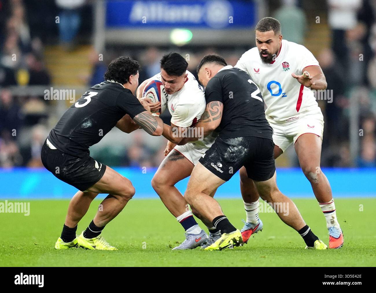 England's Marcus Smith (centre) is tackled by New Zealand's Billy ...