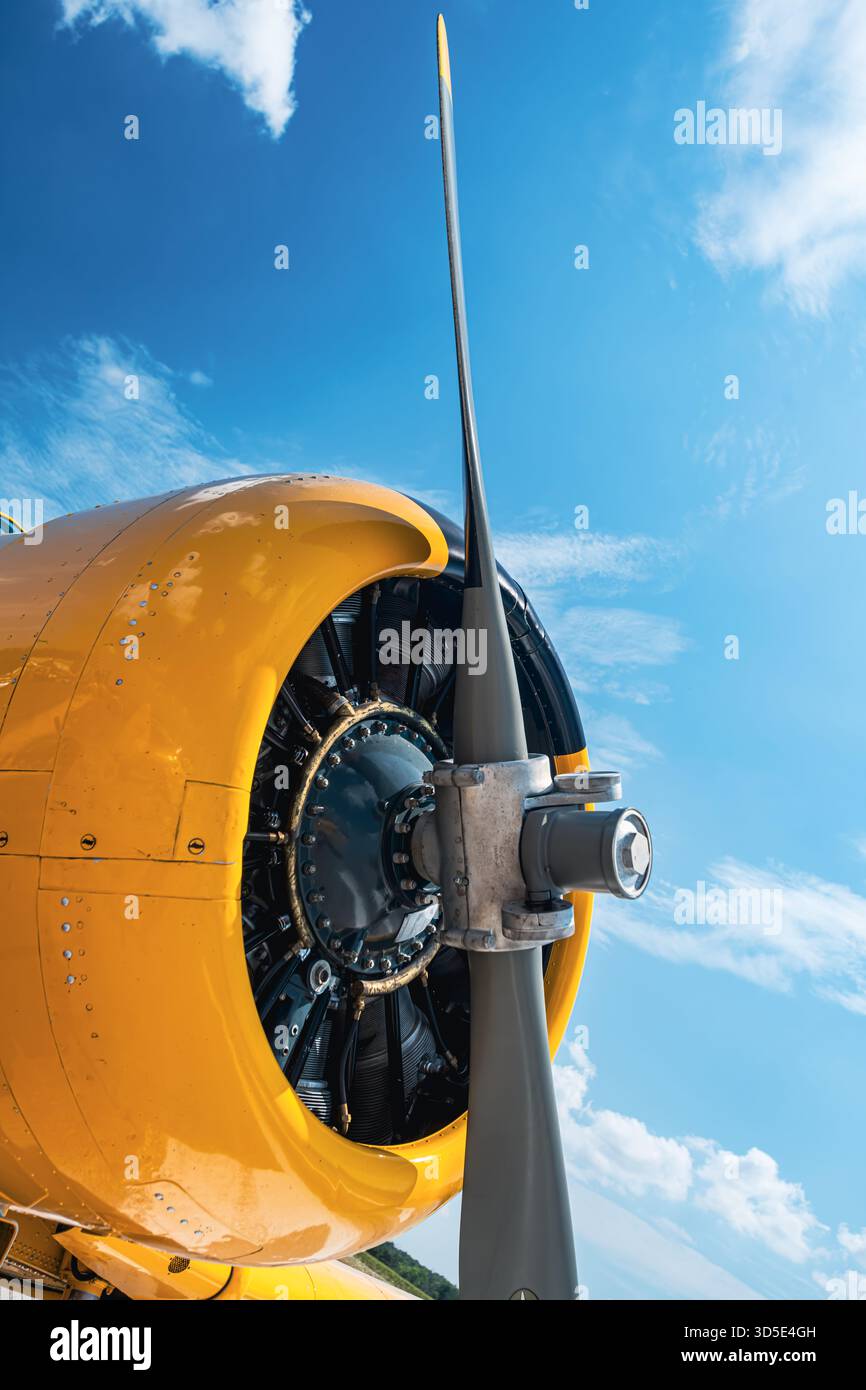 Low angle close-up of vintage yellow aircraft radial engine and silver ...