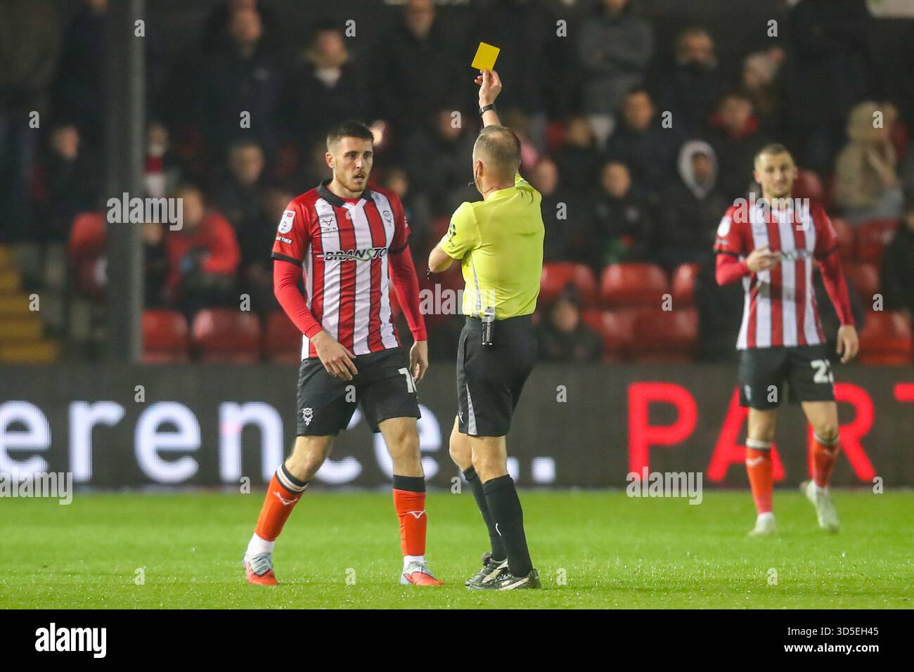 Referee David Rock shows a yellow card to Dominic Jefferies Of Lincoln ...