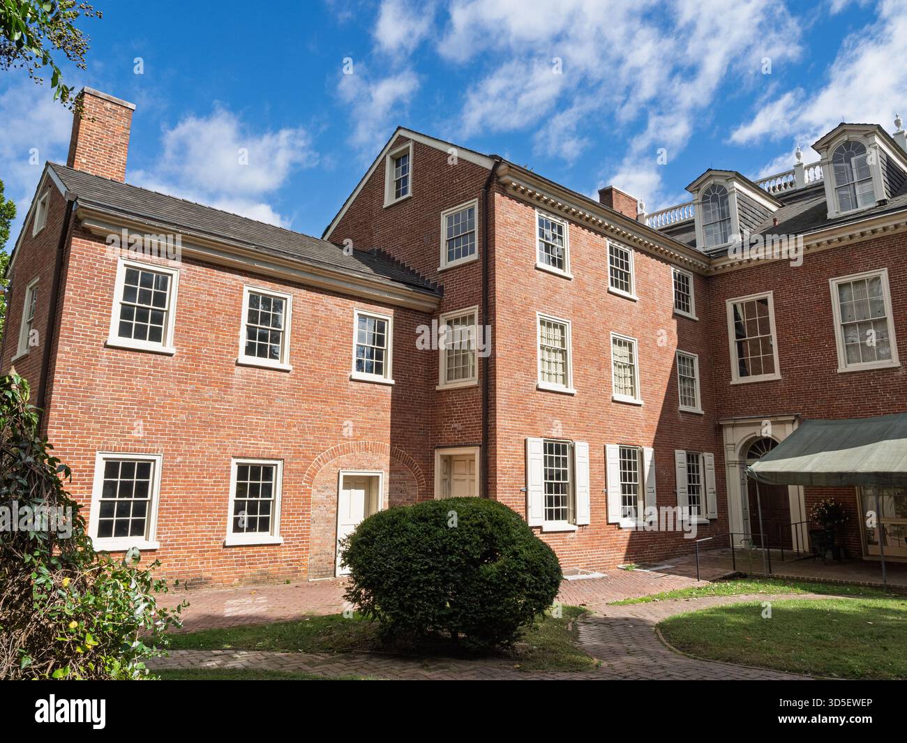 A large, striking red brick colonial building with multiple stories and ...