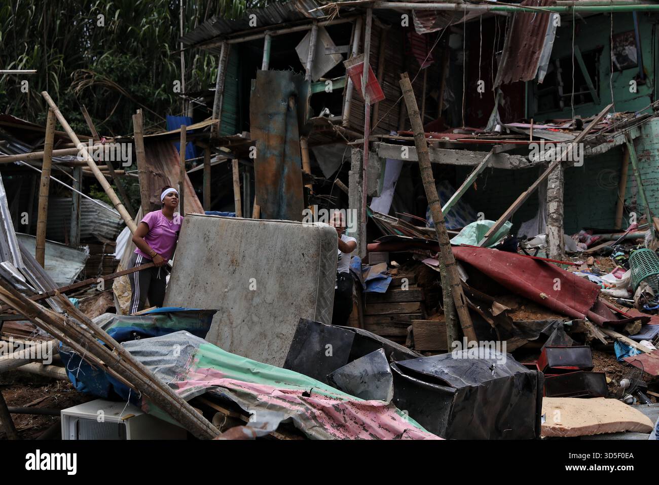 Residents save a mattress from homes destroyed in attack blamed by the ...