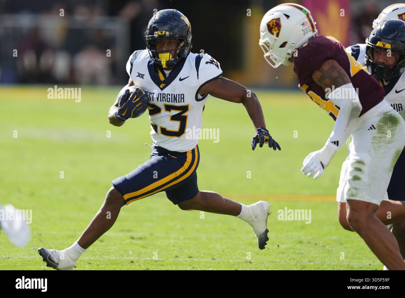 West Virginia running back Cyncir Bowers, left, runs with the ball ...