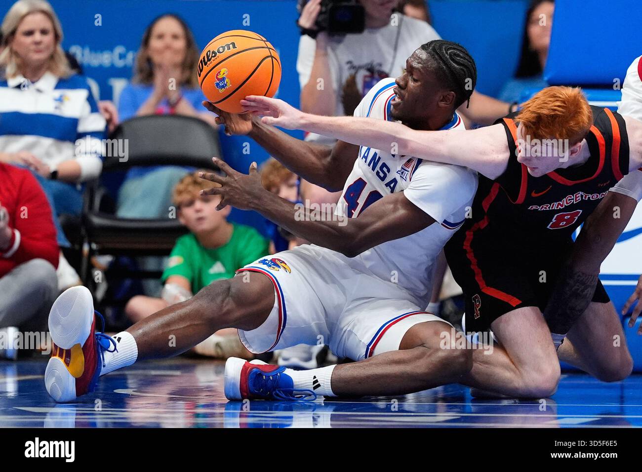 Princeton guard Landon Clark (8) tries to knock the ball away from Kansas forward Flory Bidunga ...