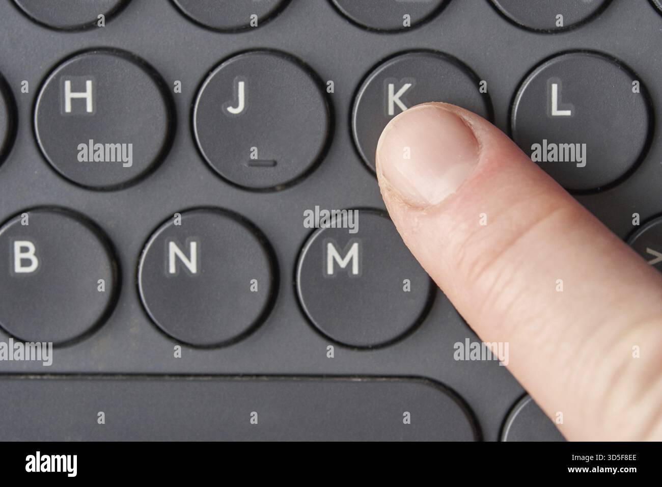 Close up of finger pressing k key on black keyboard with circular ...