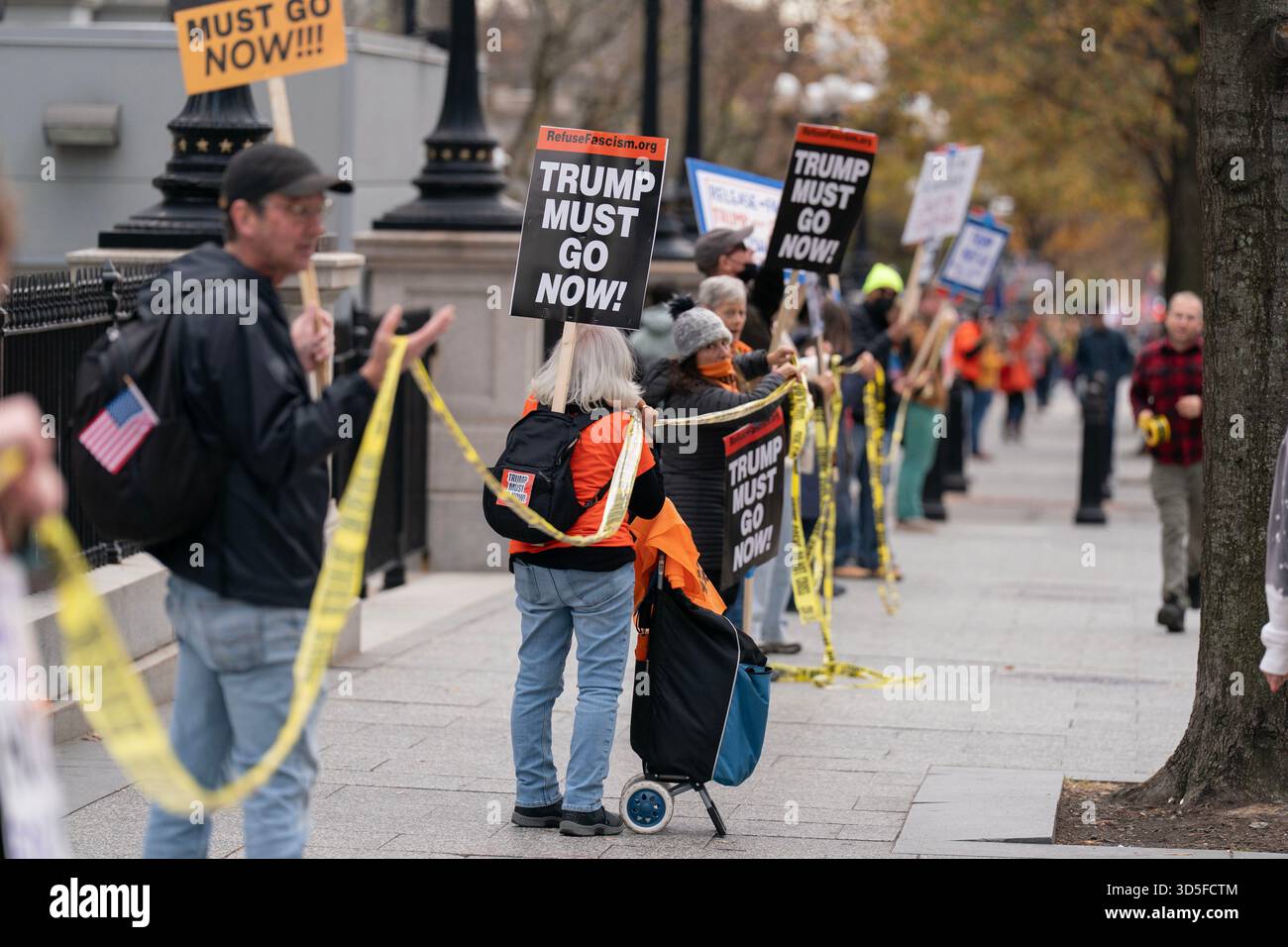 Demonstrators hold crime scene tape outside the White House complex ...