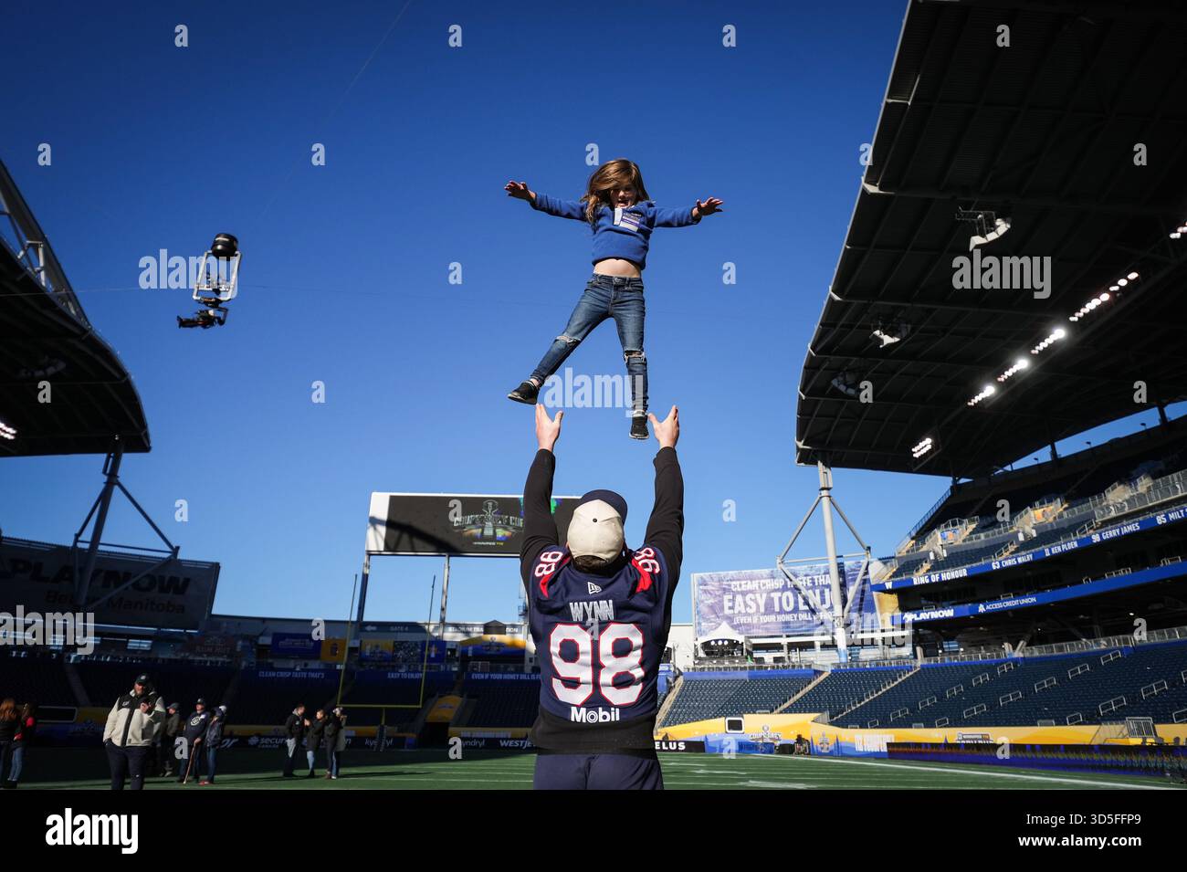 Montreal Alouettes' Dylan Wynn tosses his daughter Charlee, 5, into the ...