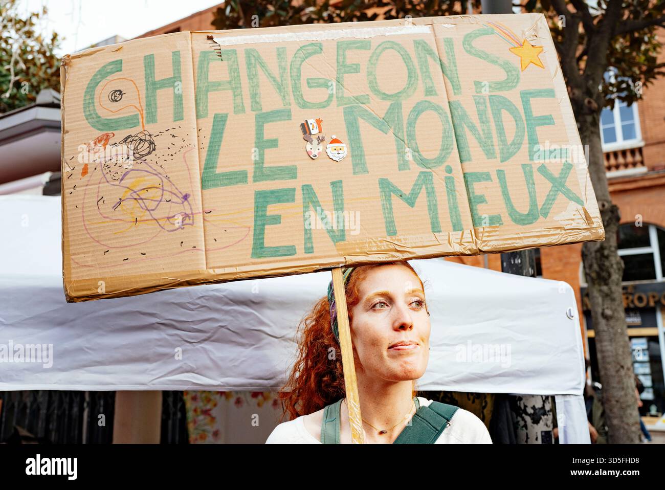 A woman holds a placard that reads, Let s change the world for the ...