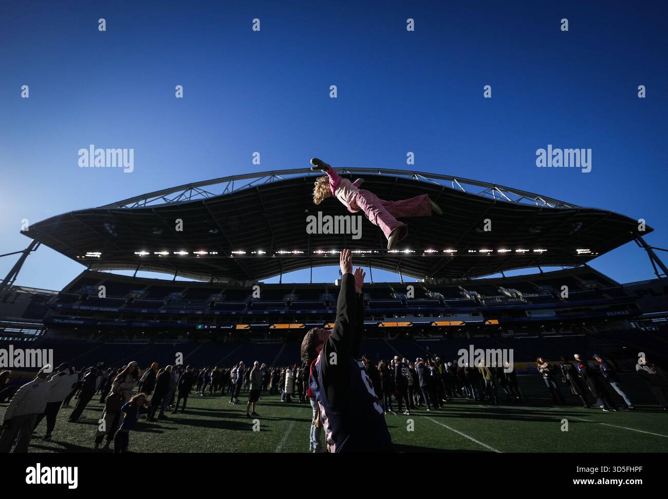 Montreal Alouettes' Dylan Wynn tosses his daughter Ivy, 3, into the air ...