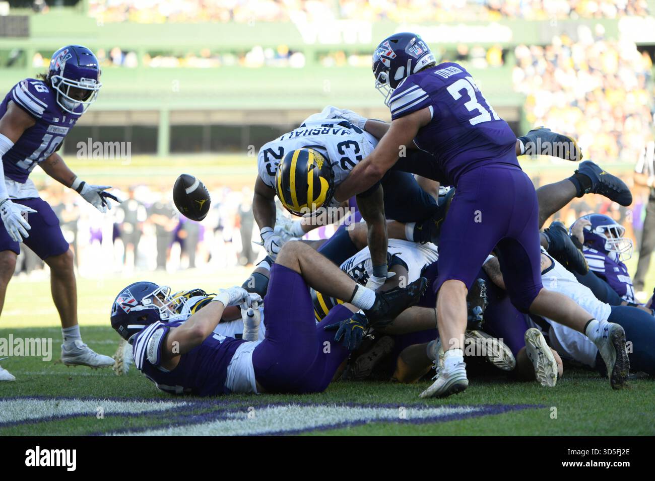 Michigan running back Jordan Marshall (23) loses the ball after rushing ...