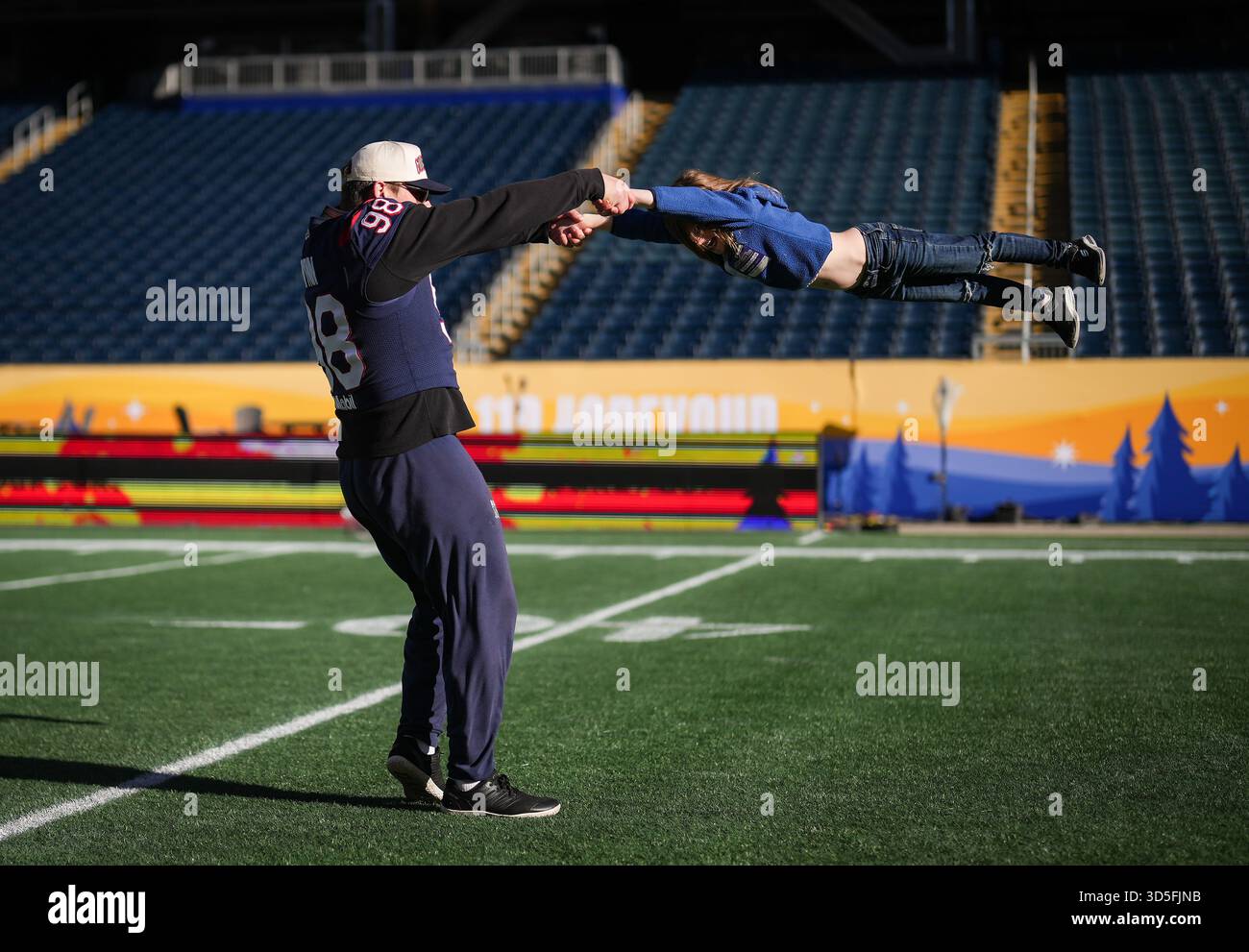 Montreal Alouettes' Dylan Wynn spins his daughter Charlee, 5, during a ...