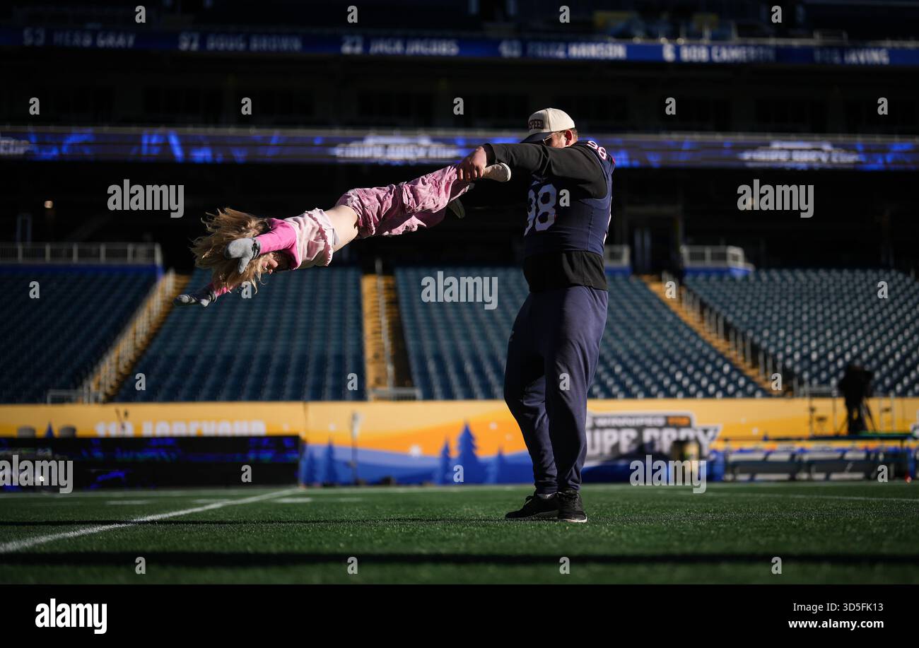 Montreal Alouettes' Dylan Wynn spins his daughter Ivy, 3, during a ...