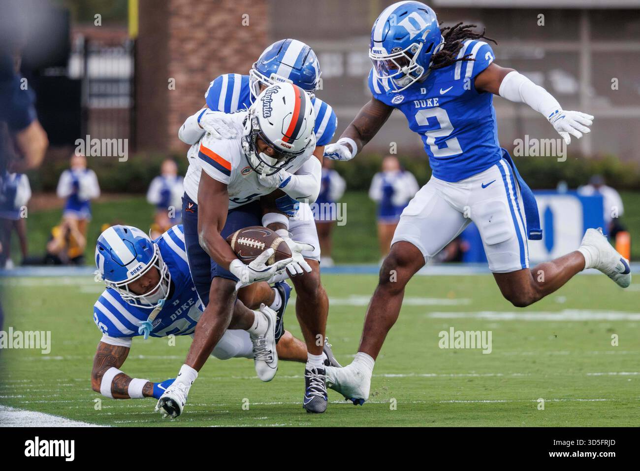 Virginia's Cam Ross (6) carries the ball ahead of Duke's Ma'khi Jones ...