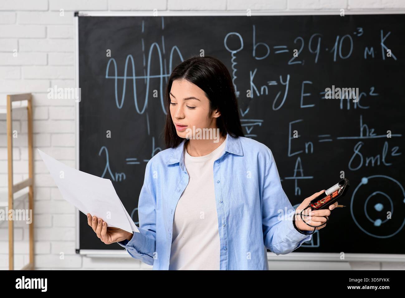 Female inventor with papers and device in workshop Stock Photo - Alamy