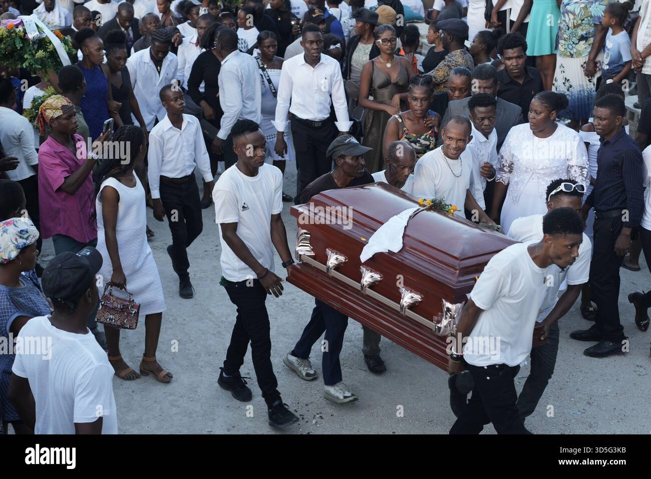 Mourners carry coffins to the cemetery during the funeral of people ...