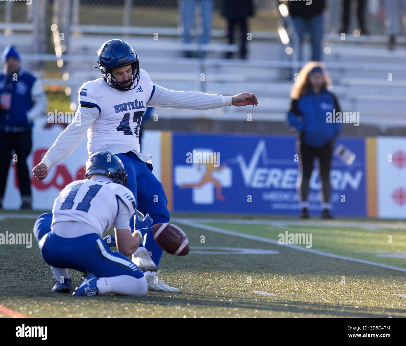 Montreal Carabins kicker Philippe Boyer kicks a field goal as teammate Louis Drolet holds the ...
