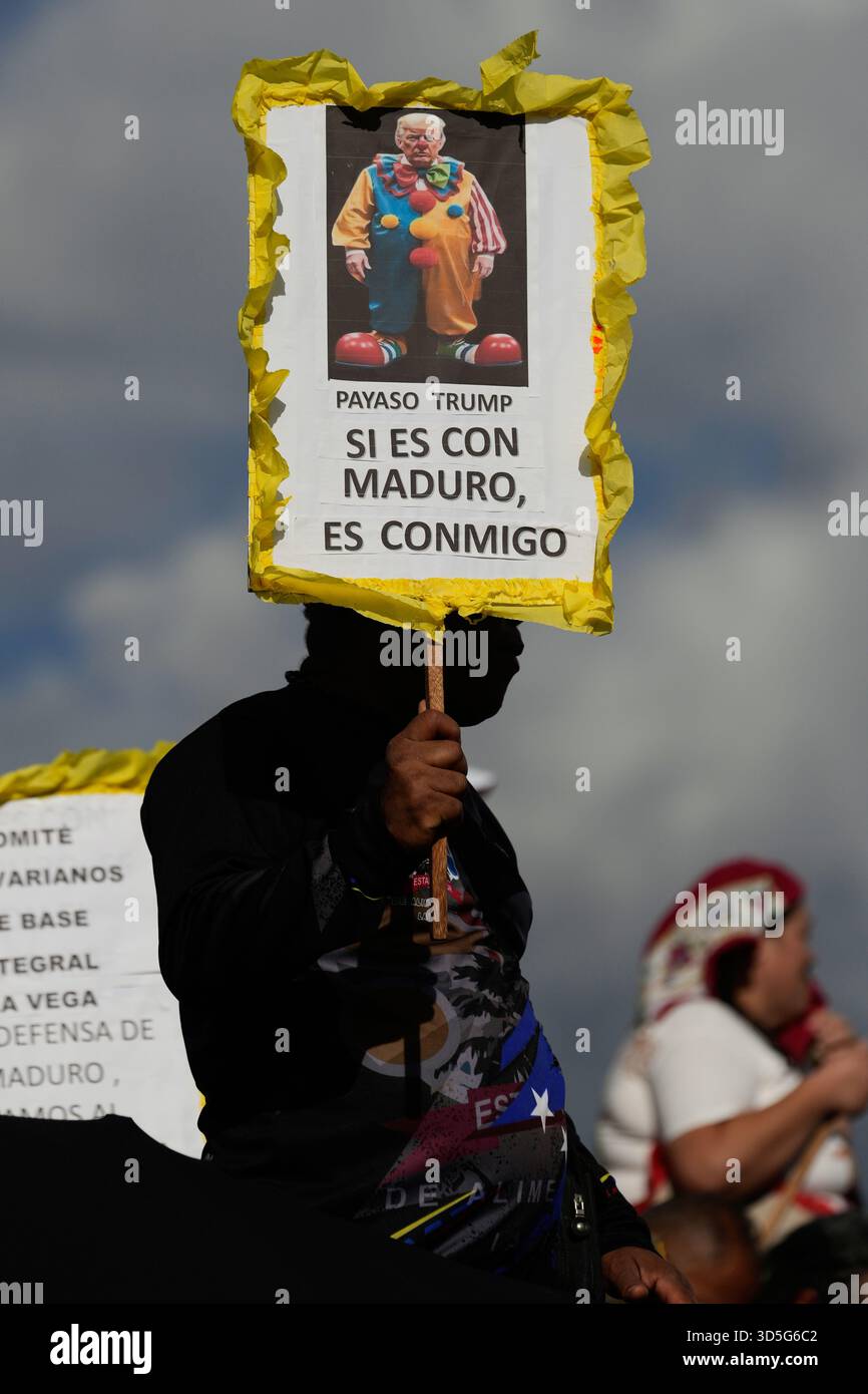 A man holds a sign reading in Spanish "Clown Trump, if you're against ...