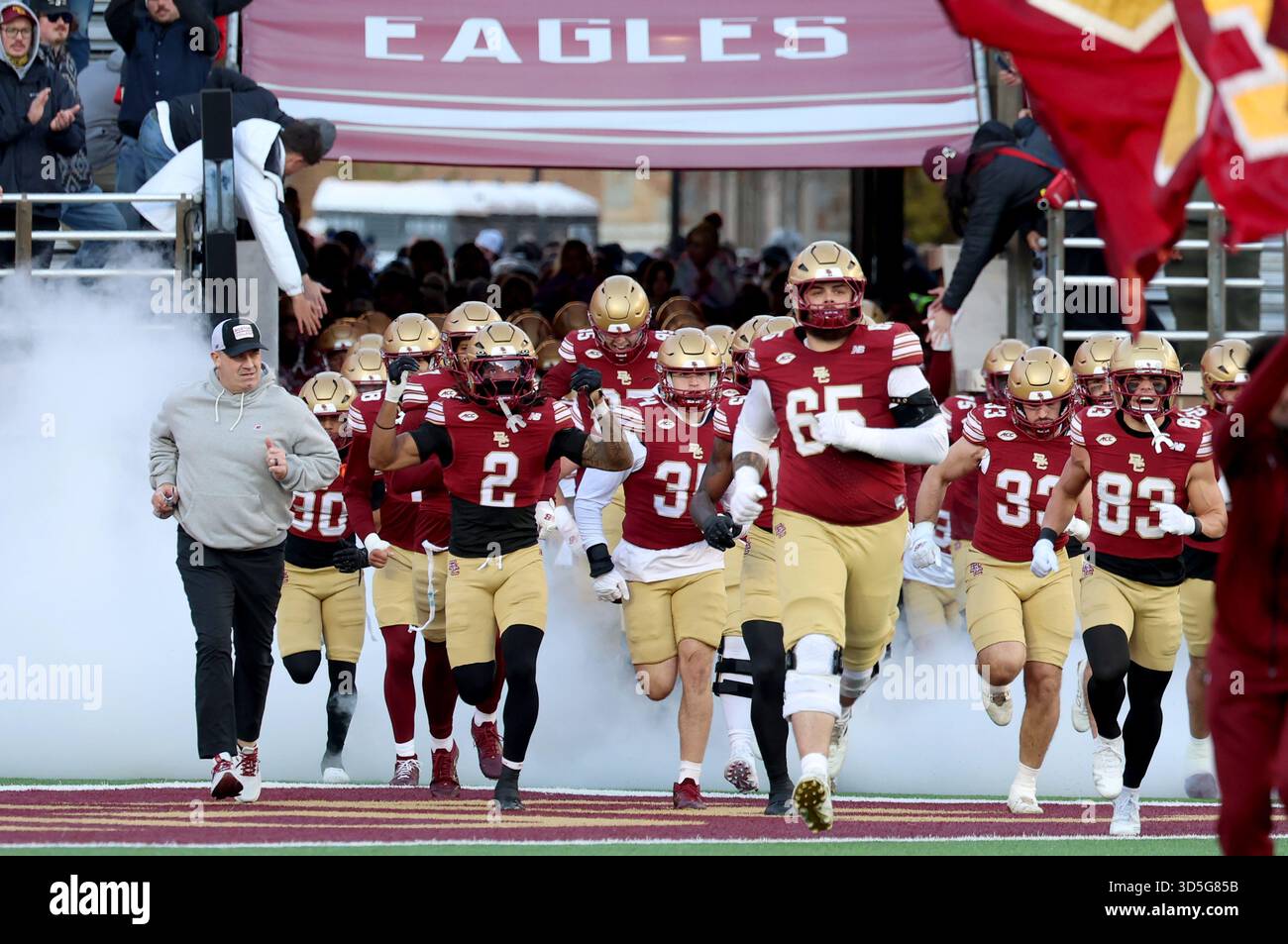 Boston College head coach Bill O'Brien, left, and his team run onto the ...