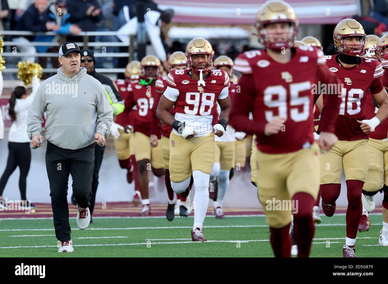Boston College head coach Bill O'Brien, left, and his team run onto the ...